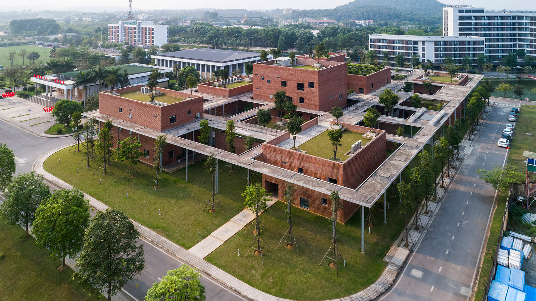 Elevated Concrete Pathway on Stilts Shades Brick Training Centre in ...
